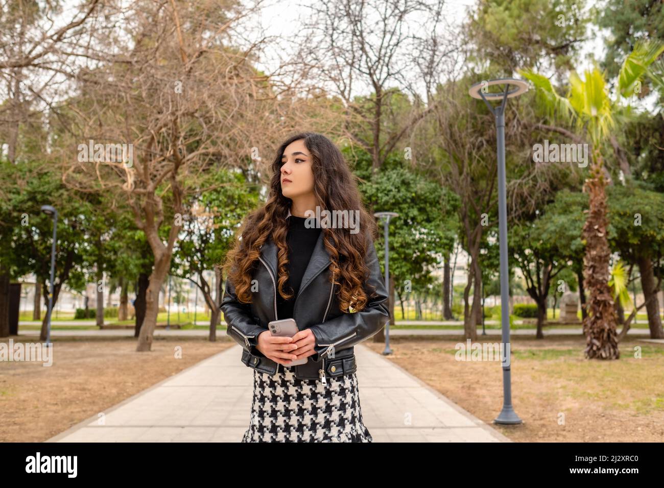 Waiting woman, young woman wearing a leather jacket is waiting for her ...