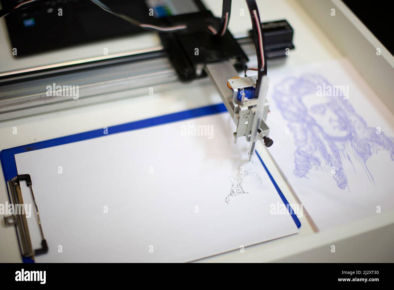 Robot Festival. The robot hand makes a drawing. Robot hand with pencil ...