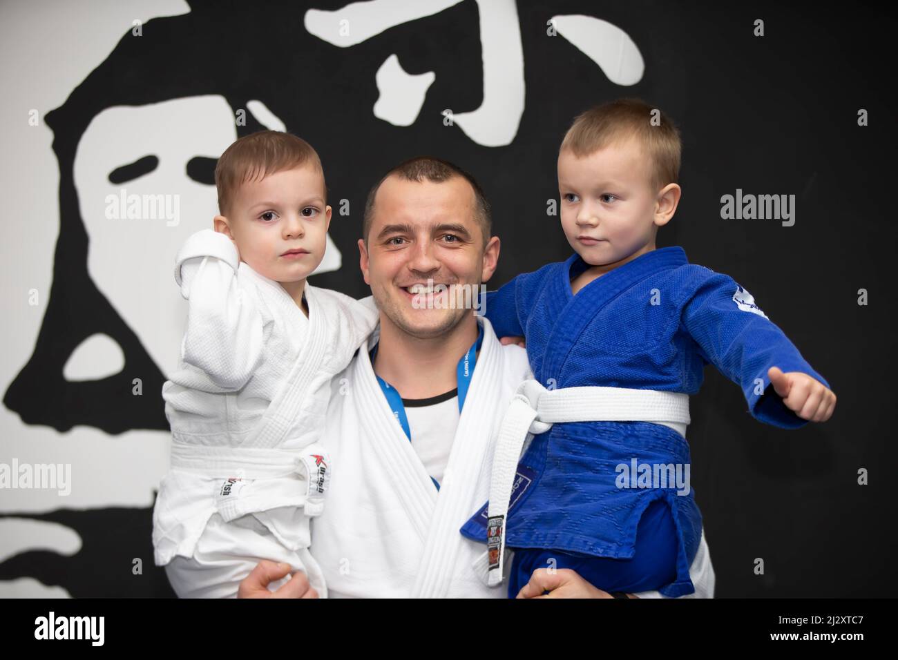 Judo school for children. The judo coach holds little students in ...