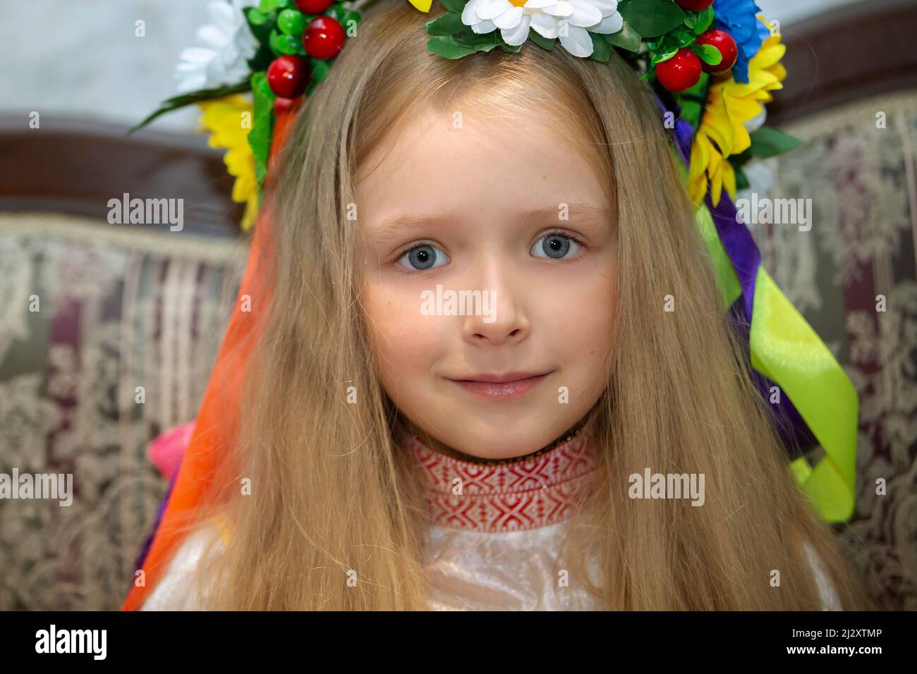 A little girl of Slavic appearance with a wreath of flowers on her head ...