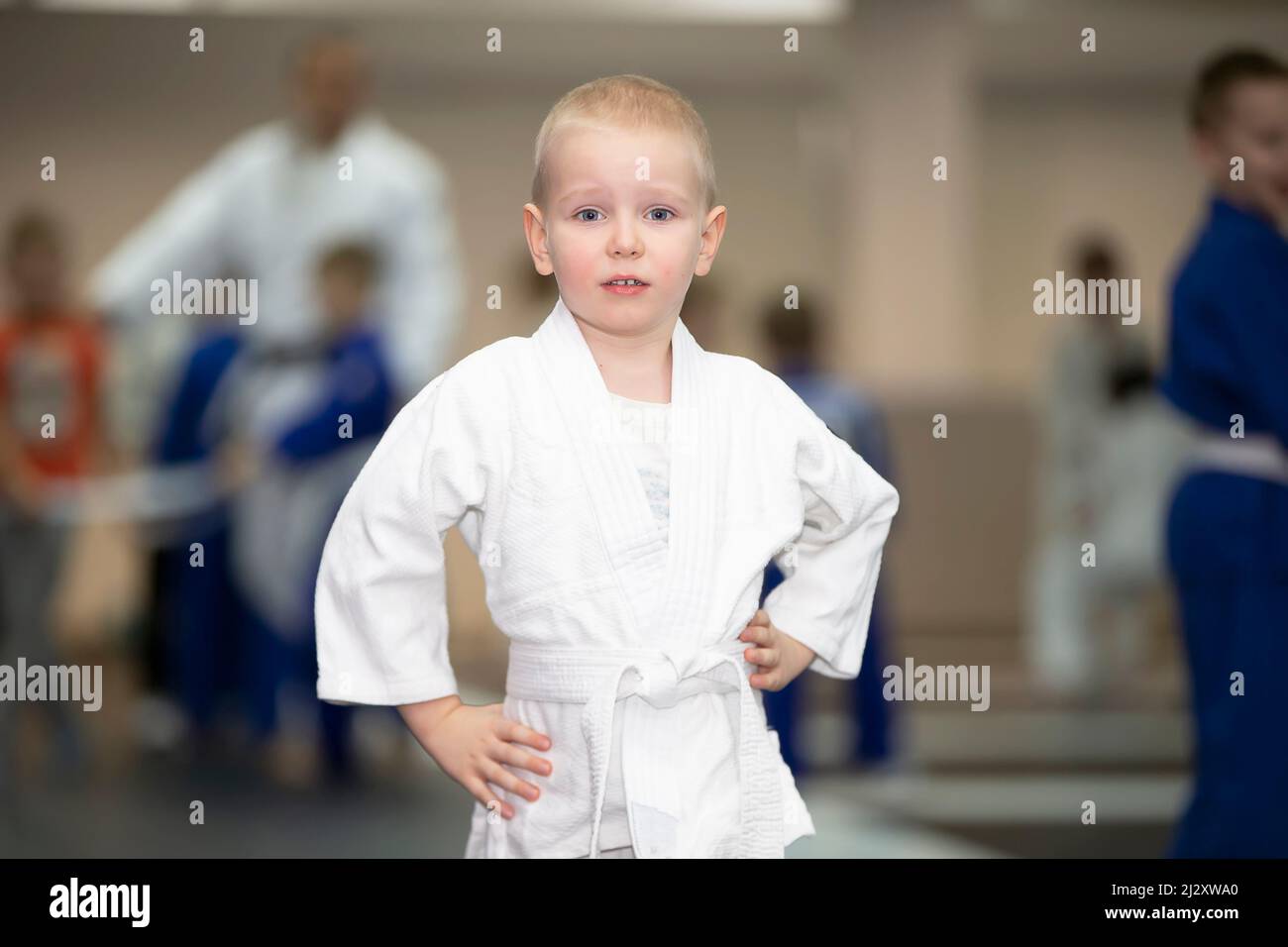 Judo school for children. A little boy in a white kimano in training ...