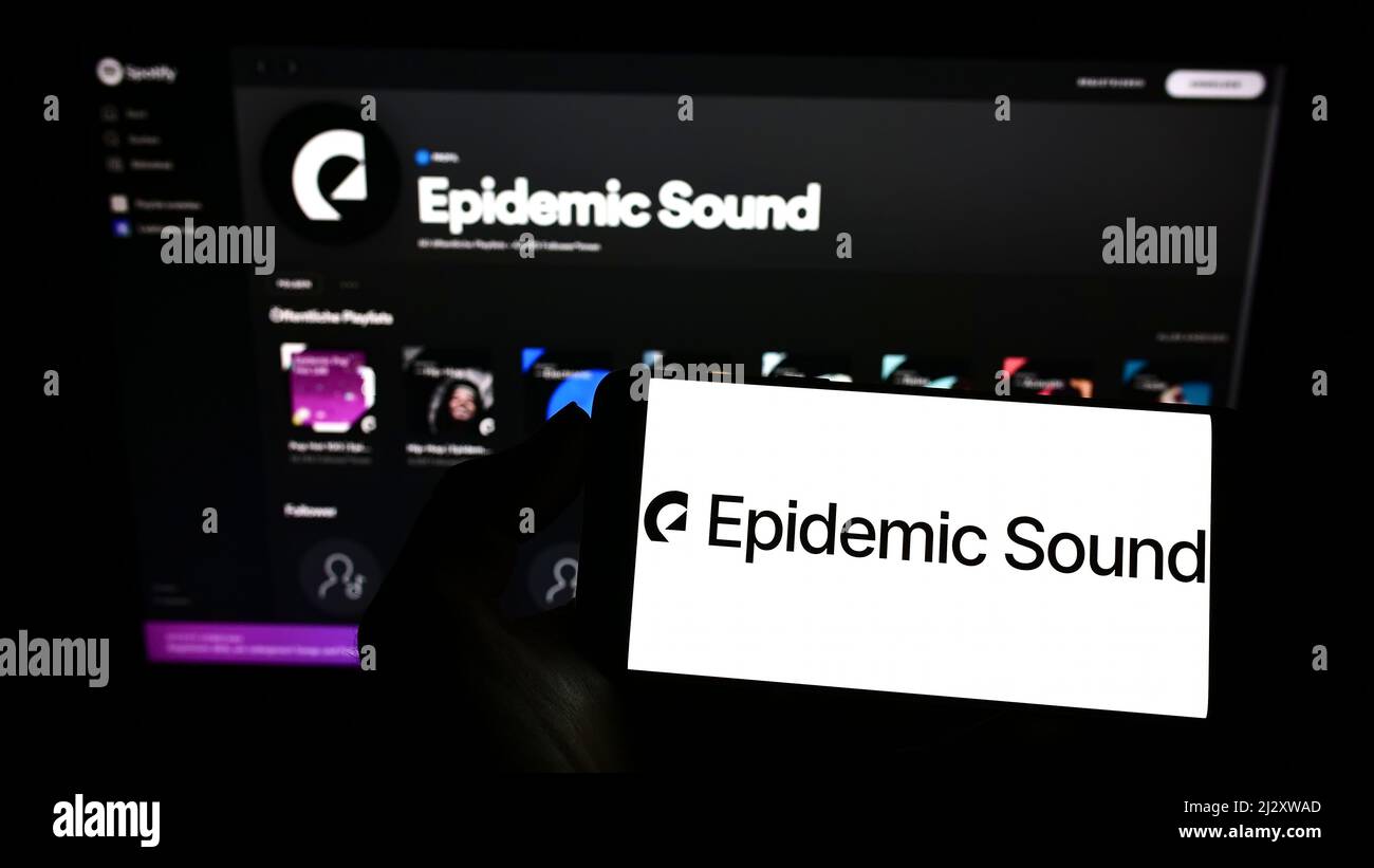 Person holding mobile phone with logo of Swedish music company Epidemic ...