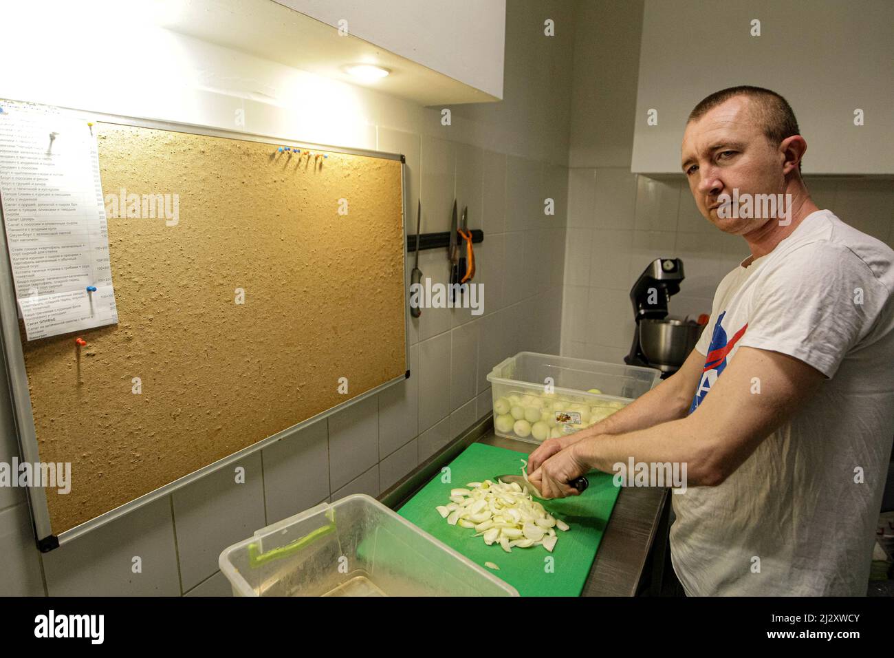 Non Exclusive: KYIV, UKRAINE - APRIL 1, 2022 - A cook slices onions as ...