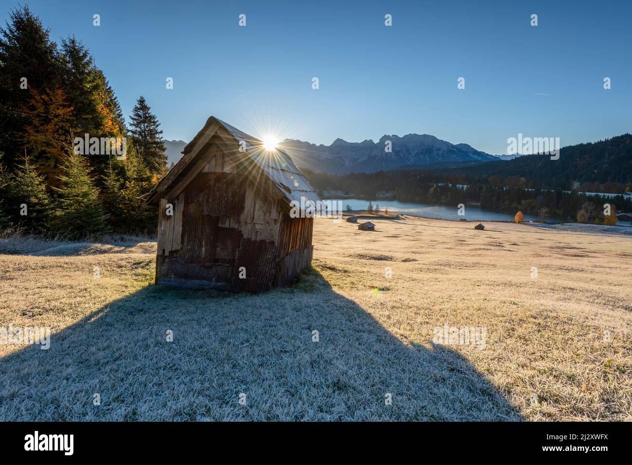 Sunrise at Geroldsee, humpback meadows with hoar frost, hay barn ...