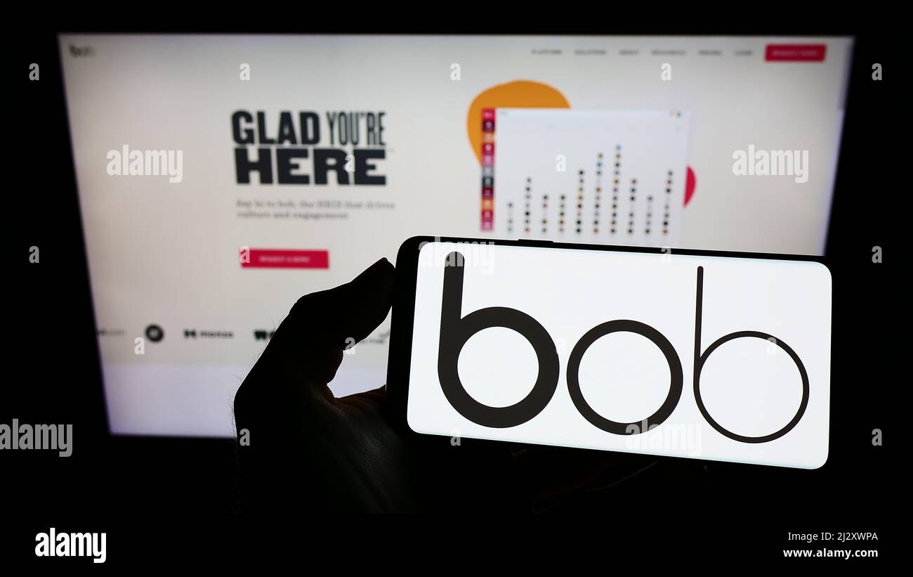 Person holding mobile phone with logo of HR software company Hi Bob ...