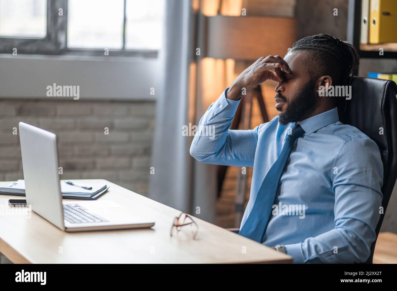 Exhausted company employee suffering from the eyestrain Stock Photo - Alamy