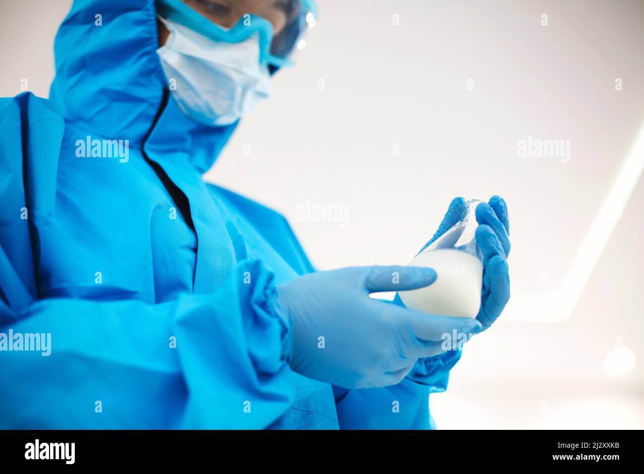 Female lab scientist examining samples in a test tube, working in an ...