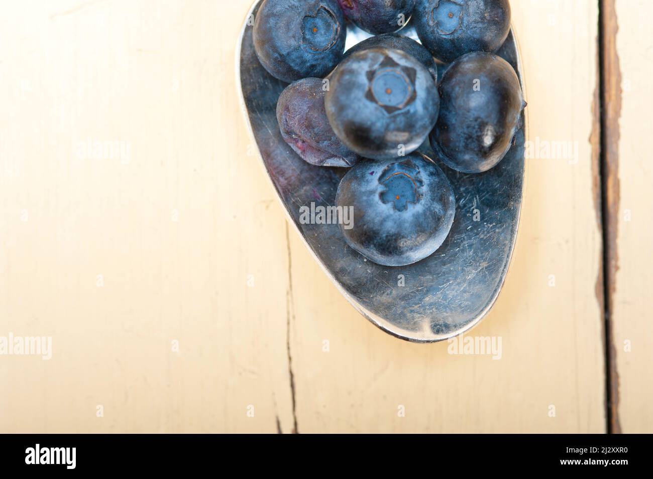 fresh blueberry on silver spoon over a white rustic wood table Stock ...