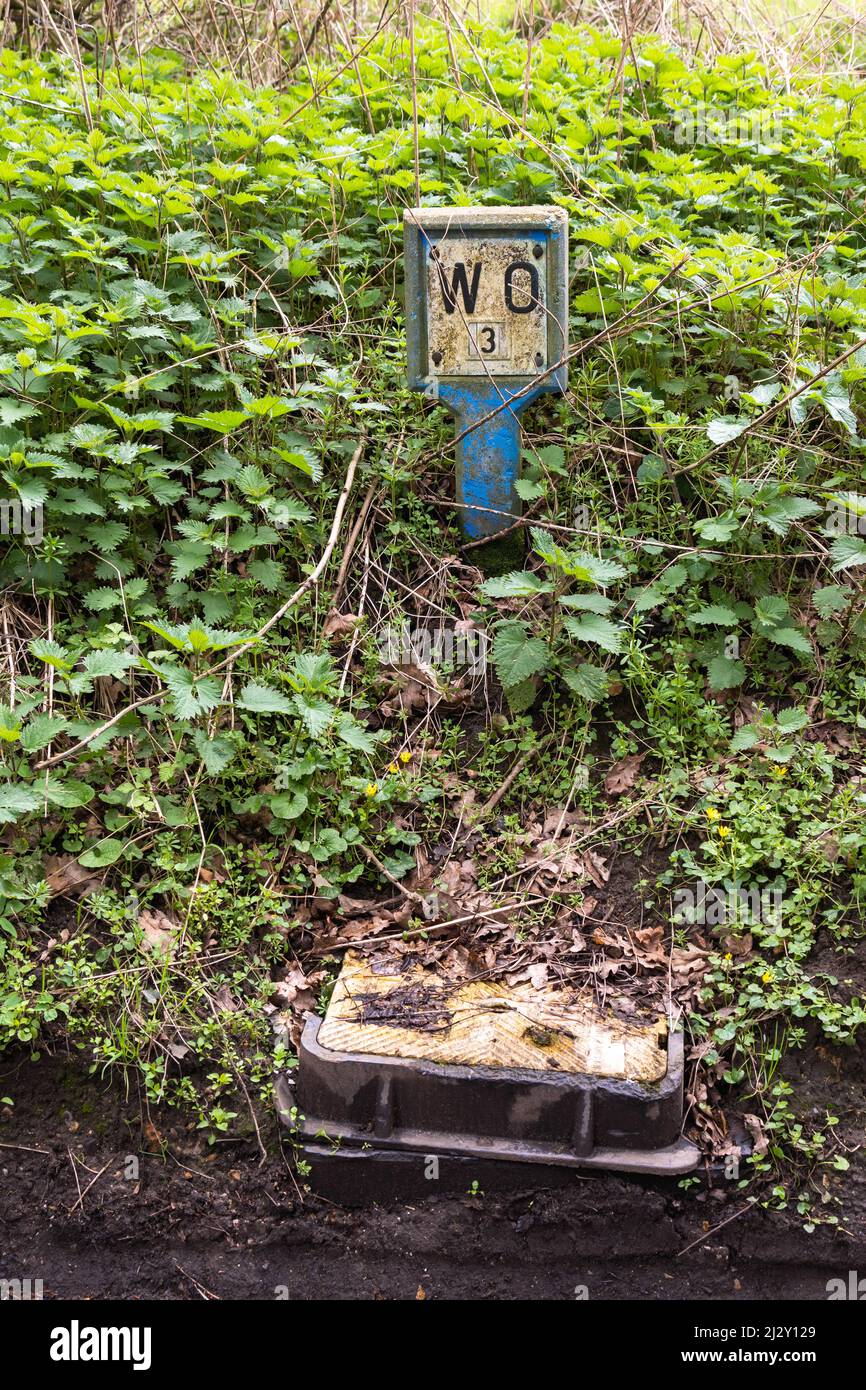 Water meter post with manhole drain visible due to erosion of ground ...