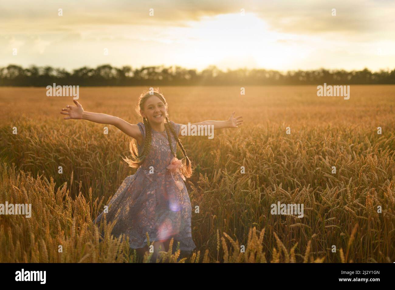 Girl running in wheat field at a sunset Stock Photo - Alamy