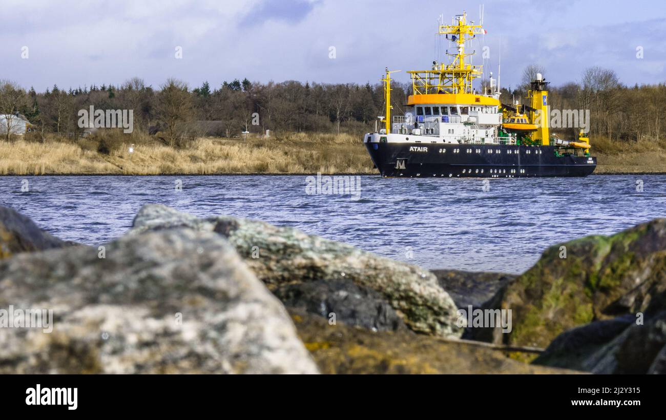 A black and yellow construction boat floating on a river Stock Photo ...