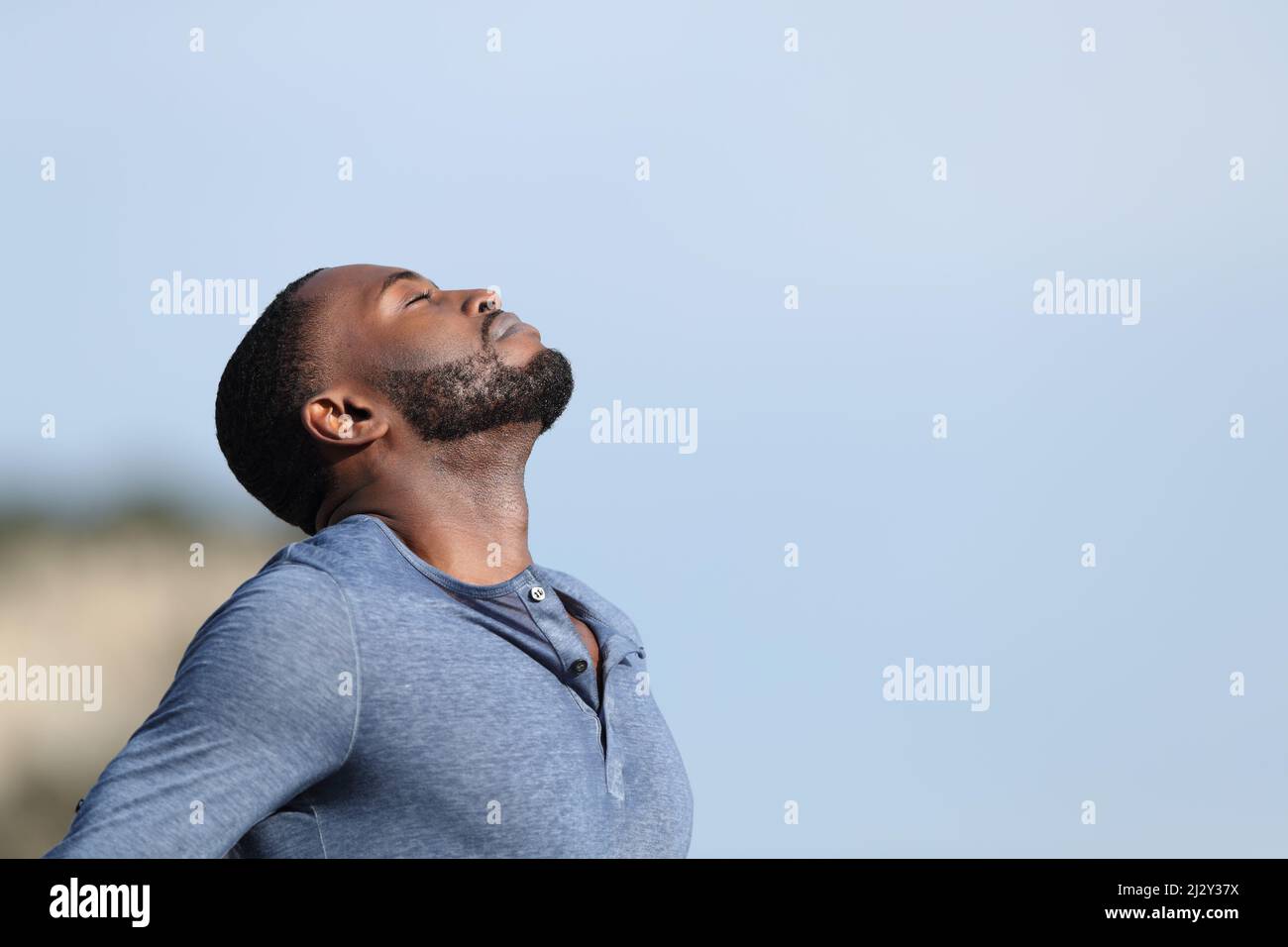 Profile of a man with black skin breathing fresh air standing in nature ...