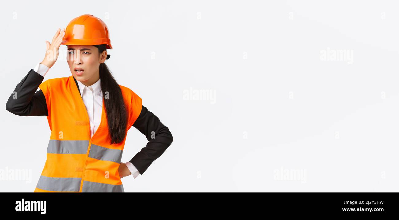 Annoyed and disappointed female asian chief engineer scolding ...