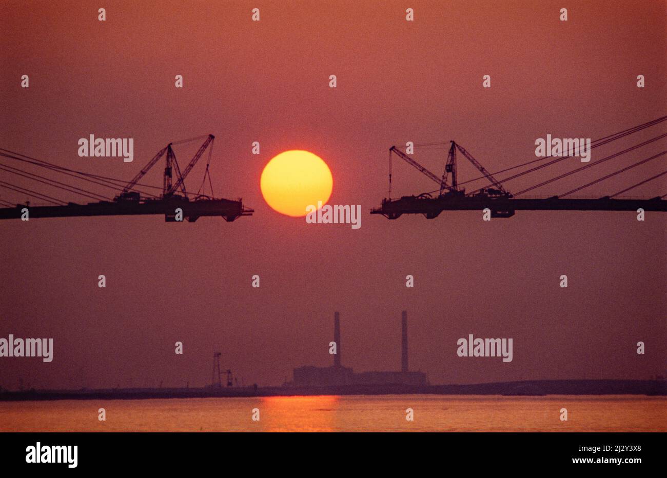 Sun setting between the two ends of The QE2 bridge at Dartford prior to ...