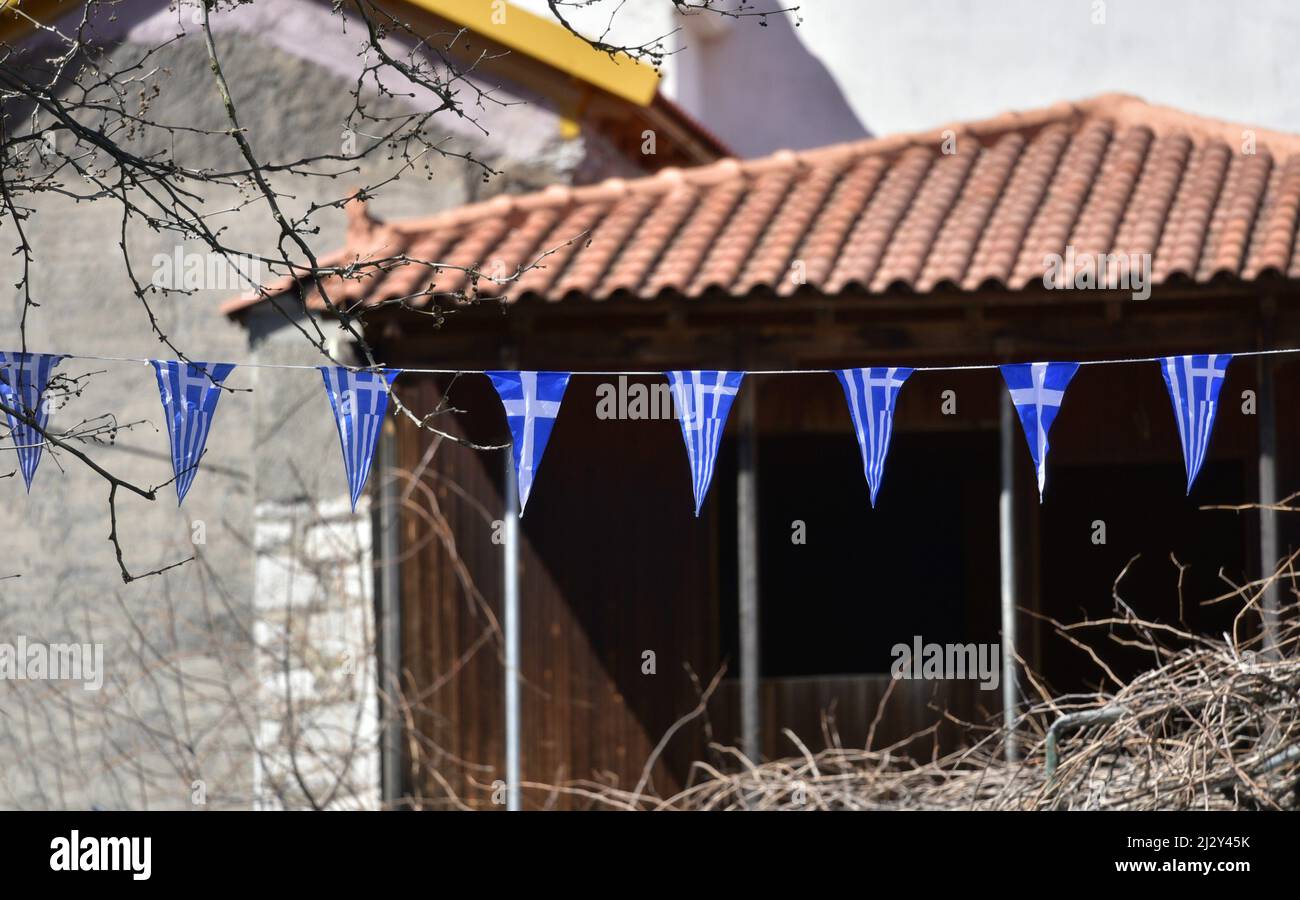 Festive Greek flags hanging under a red clay tile rooftop celebrating ...
