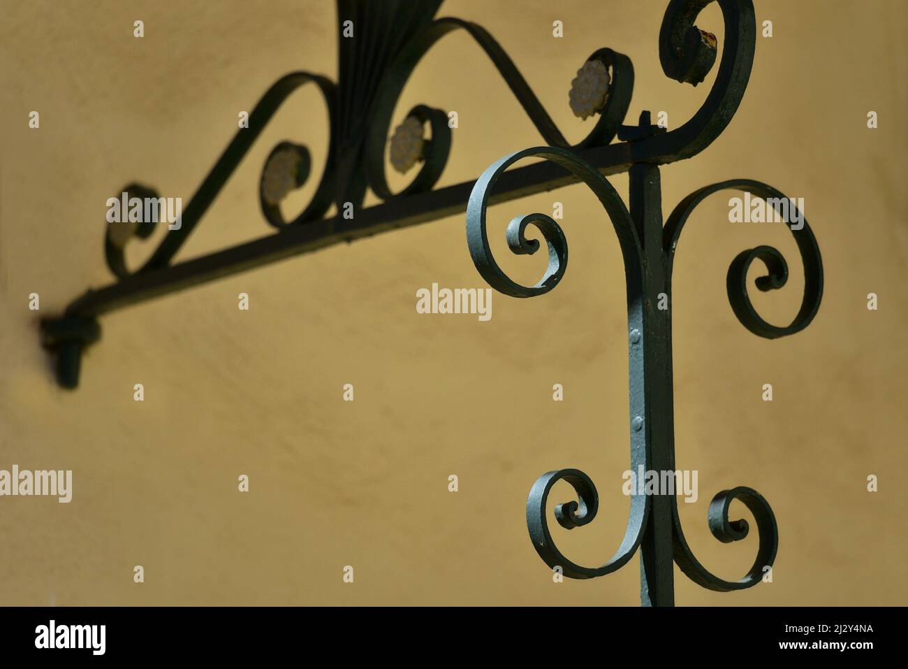 Traditional handcrafted wrought iron wall lantern support against an ...