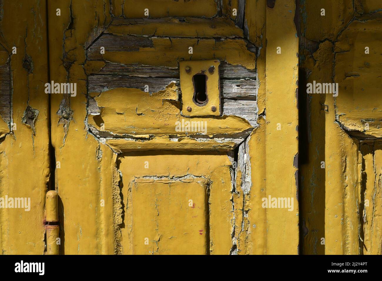 Antique ochre wooden entrance door with chipped paint and a rusty metal ...
