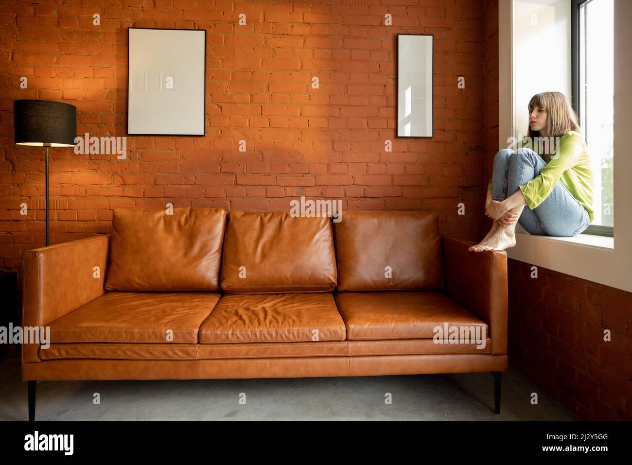 Woman sits on the window sill alone at home Stock Photo - Alamy