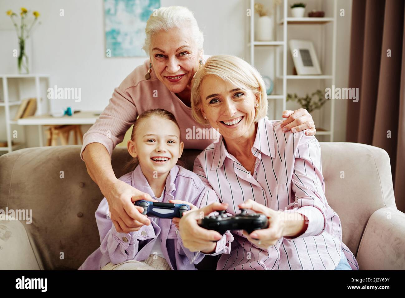 Front view portrait of three generation family playing video games at ...