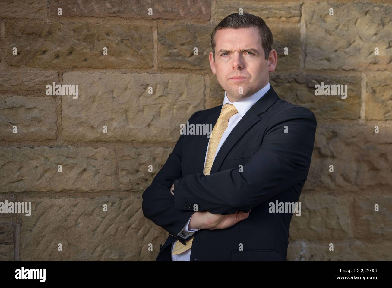 Douglas ross in dark suit with sandstone wall backdrop hi-res stock ...