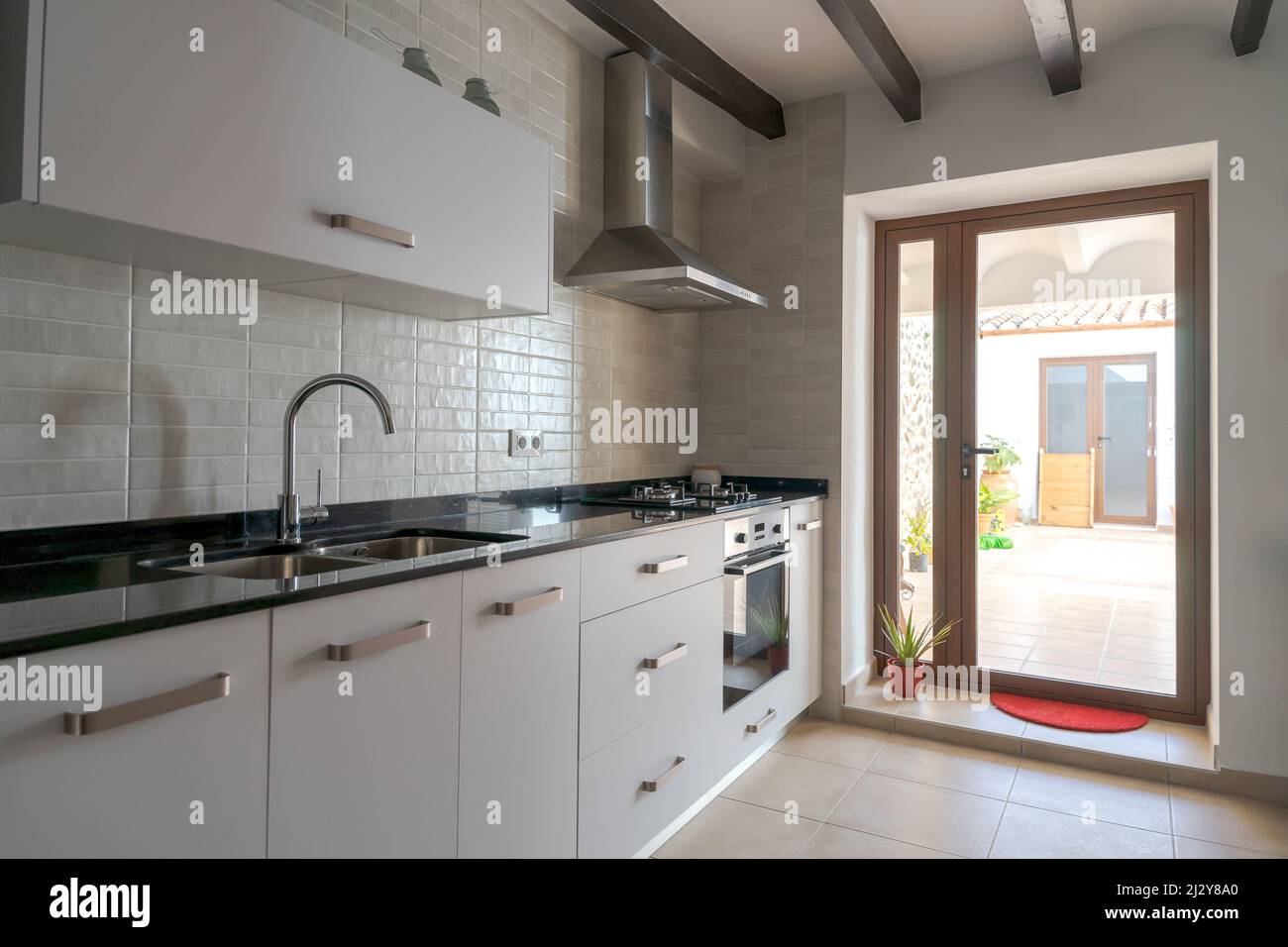 White kitchen with natural light from the yard. White furniture with ...