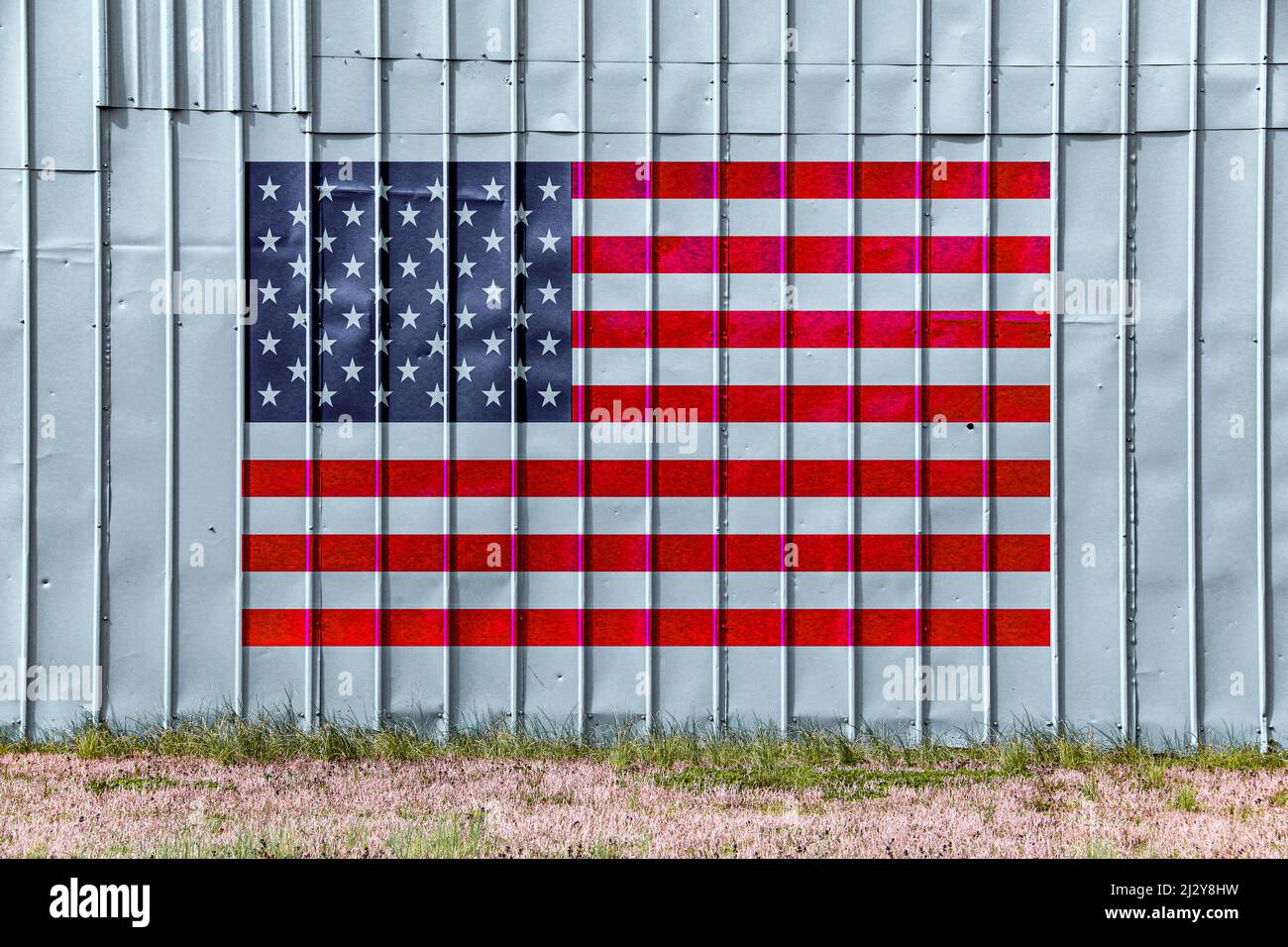 a beautiful blue warehouse factory wall with grass in the sunlight ...