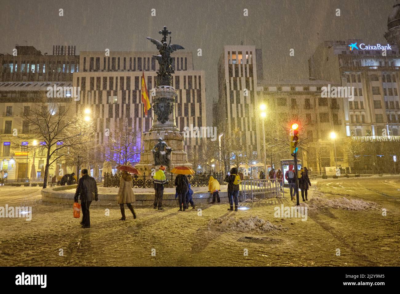 Image of a snowy city at night, with people walking through the streets ...