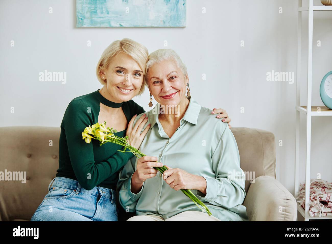 Front view portrait of adult daughter with mother looking at camera in ...