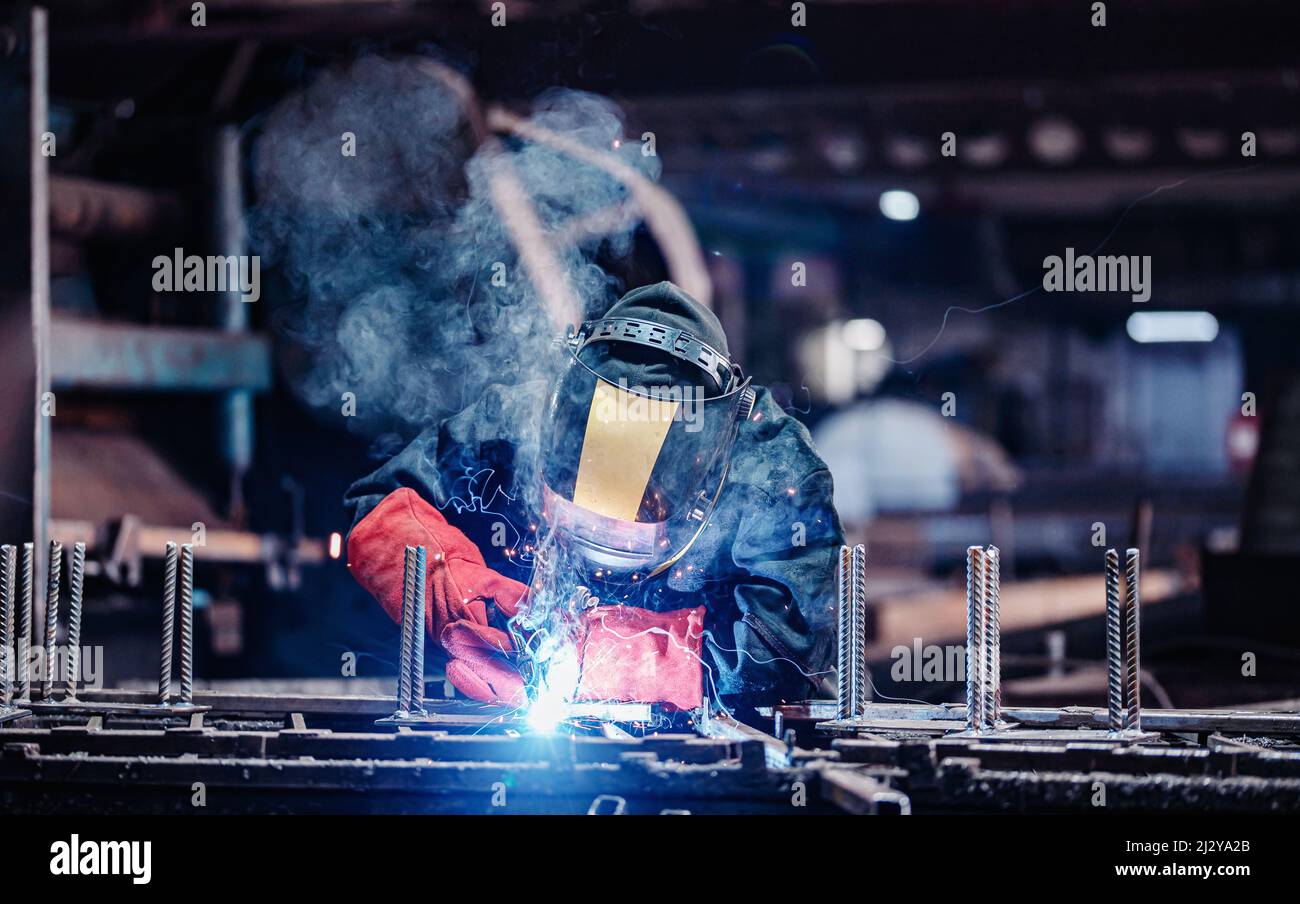 Factory industrial weld worker in workplace with spark. Professional ...