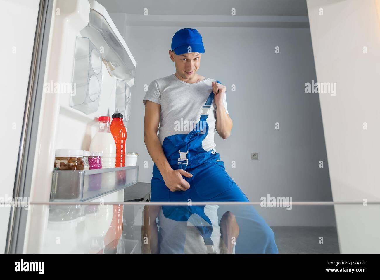 Cheerful male repairman in uniform is dancing a private dance near the ...