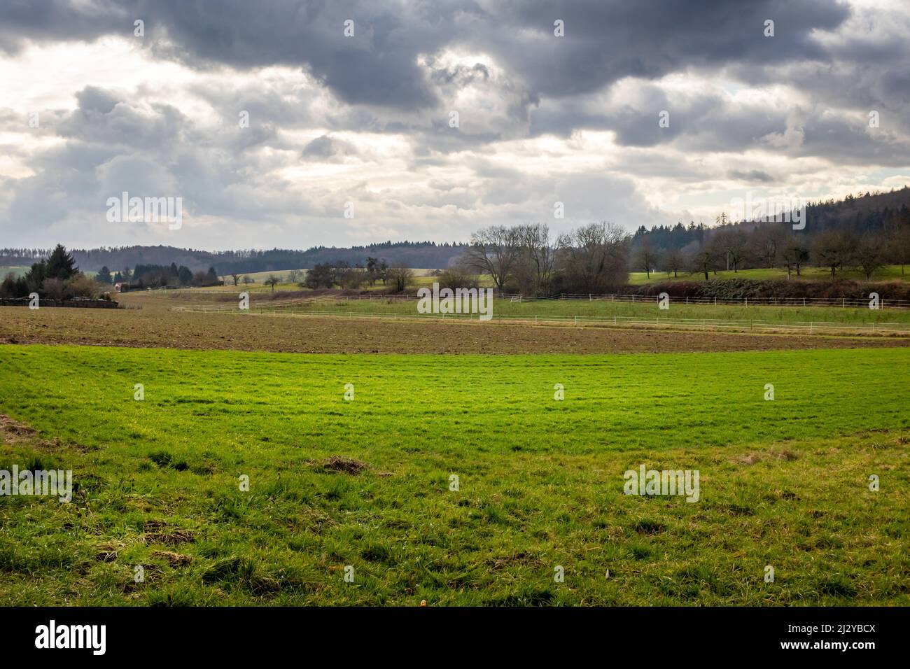 meadow and field landscape in southern Germany with dramatic clouds ...