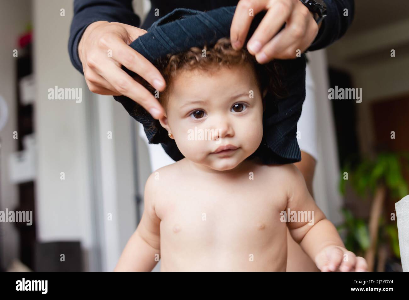 portrait front view caucasian baby standing in the living room at home ...
