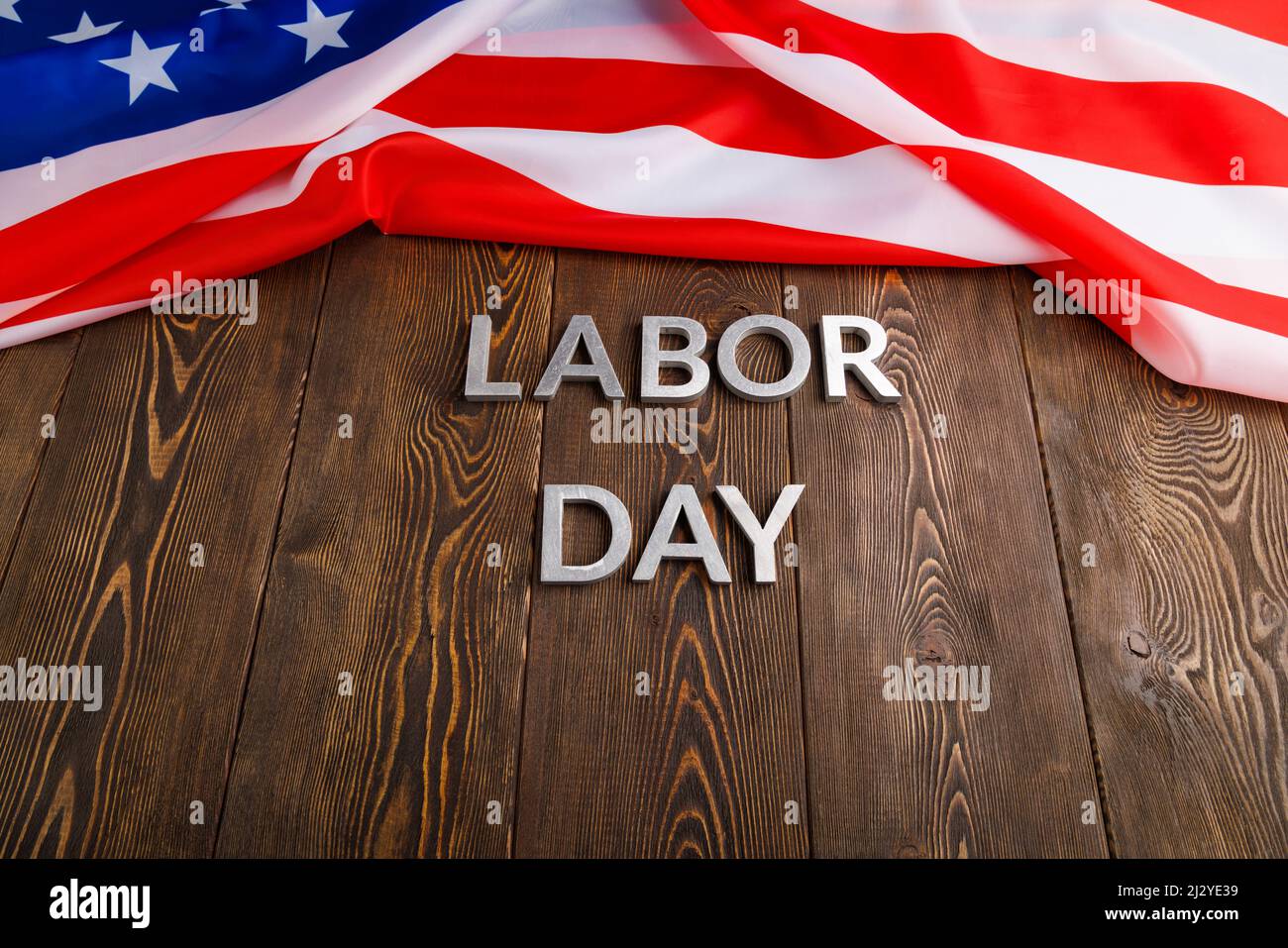words labor day laid with silver metal letters on wooden surface with ...