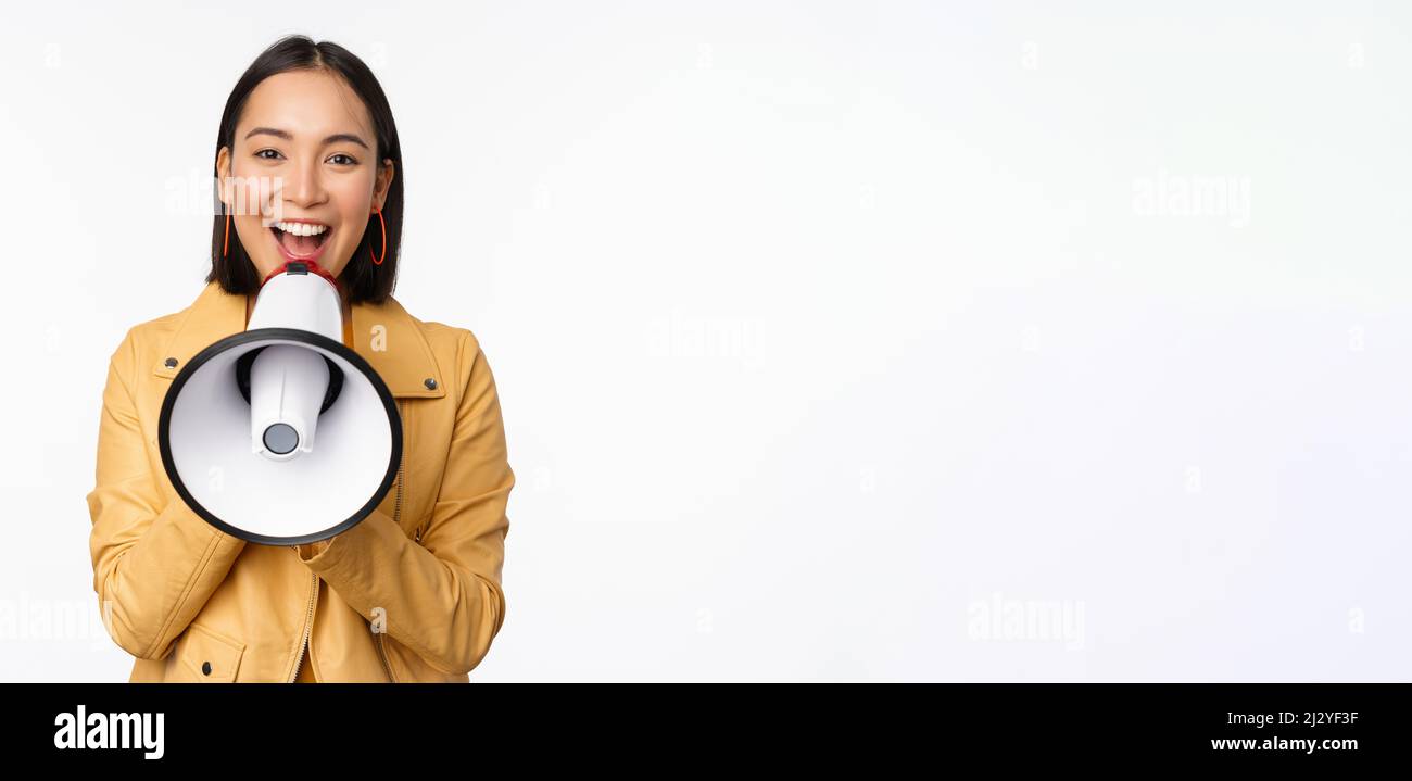 Attention announcement. Image of asian woman shouting in megaphone ...