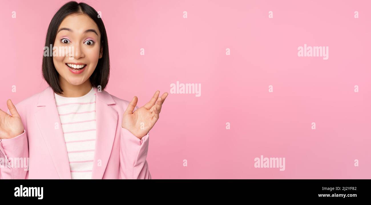 Portrait of asian businesswoman looking surprised at camera, clapping ...