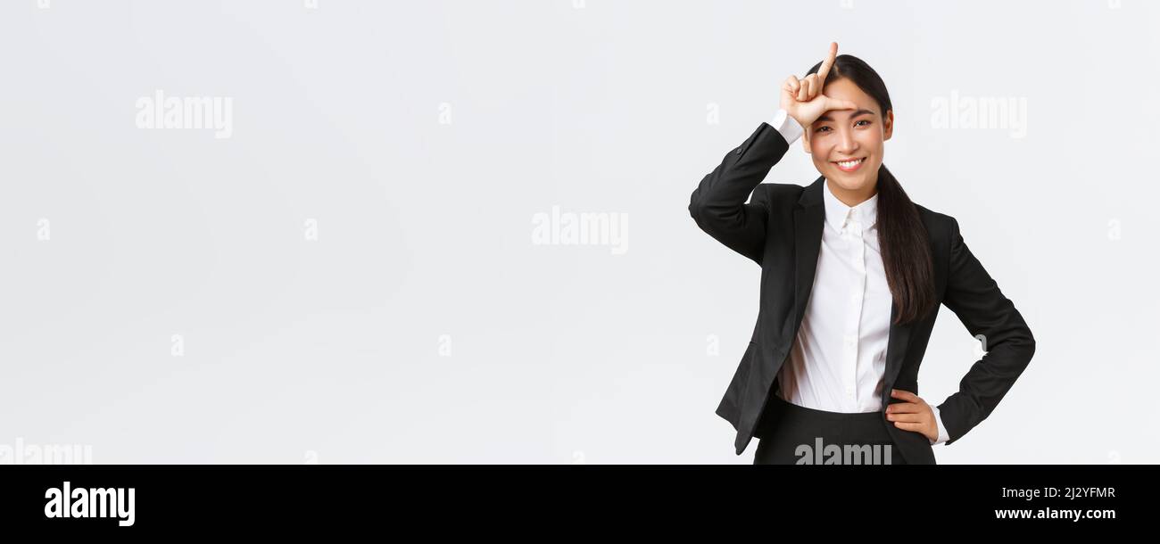 Successful asian businesswoman in black suit mocking her rivals ...