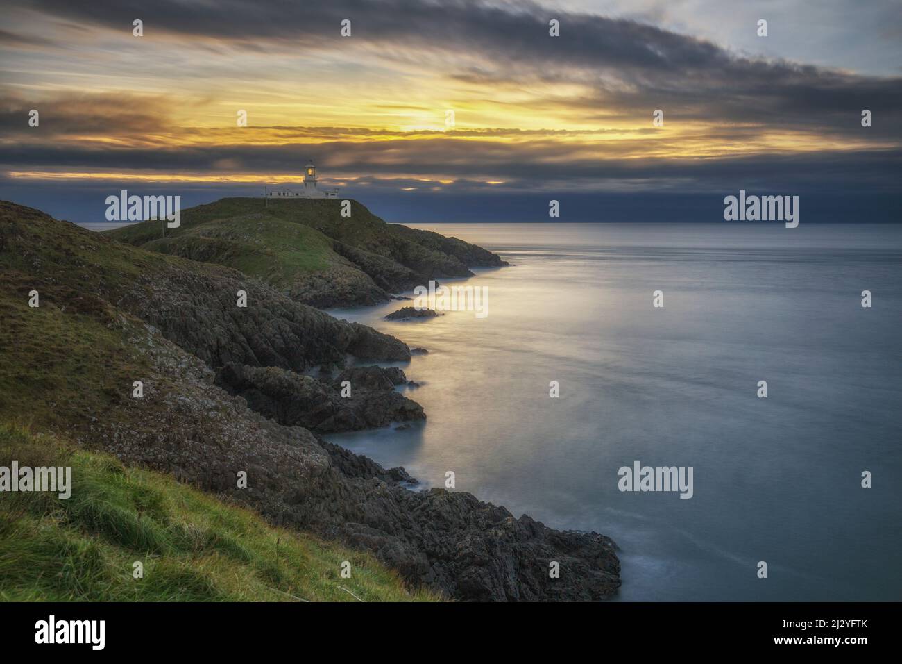 View along the coast towards sunset at Strumble Head Lighthouse in ...