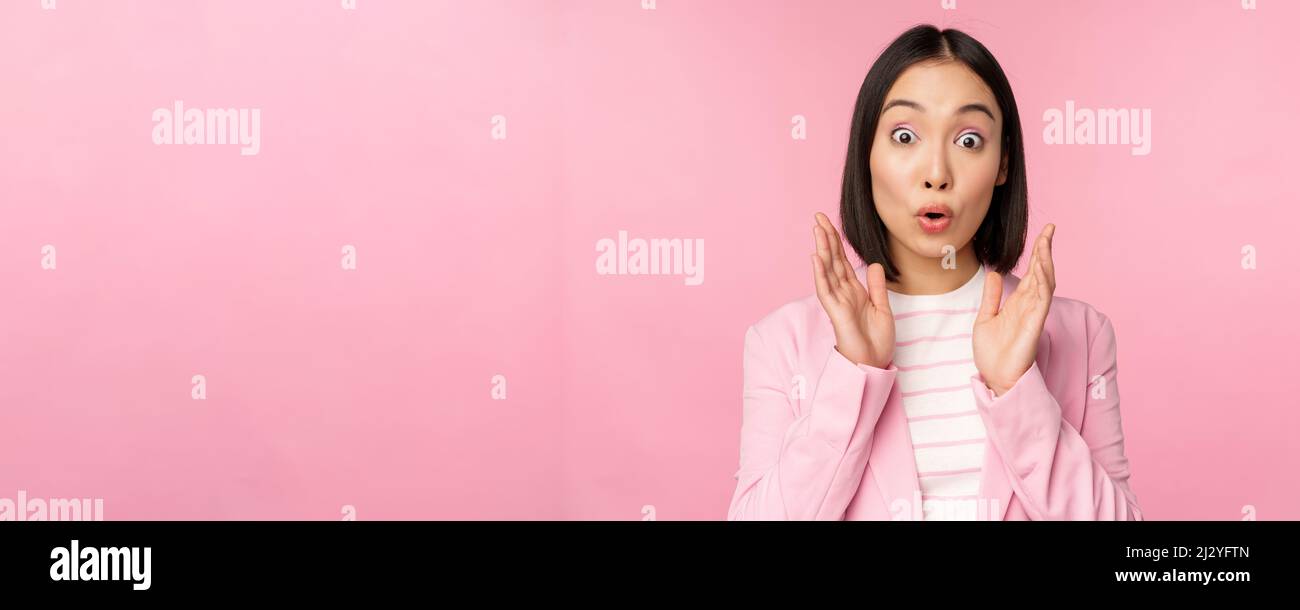 Portrait of asian businesswoman looking surprised at camera, clapping ...