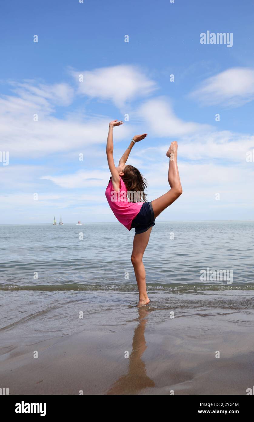 slender young girl with short pants performs a rhythmic gymnastics ...