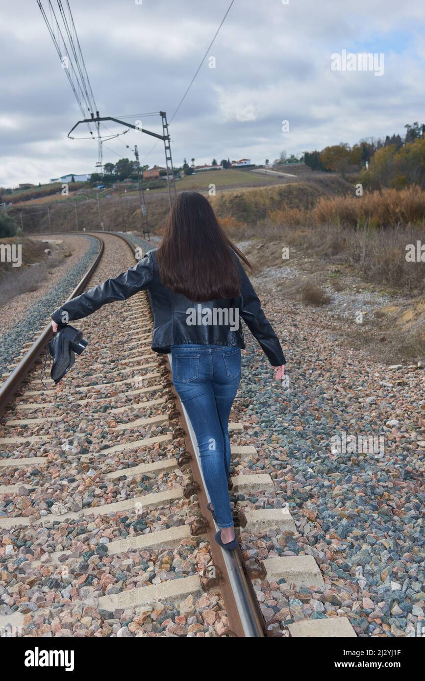 A daring barefoot girl balancing on some train rails Stock Photo - Alamy