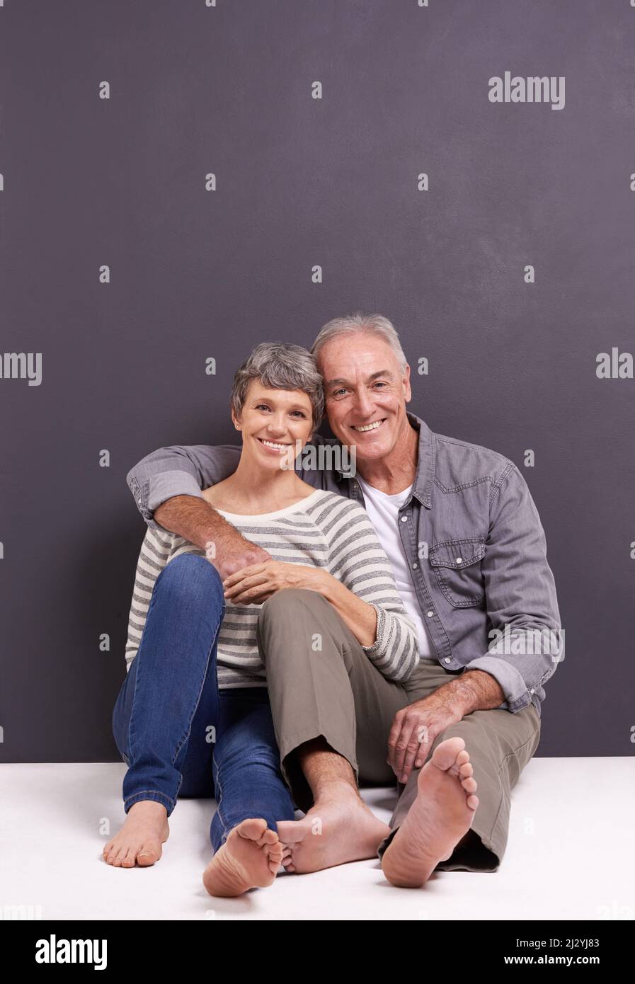 Sharing a lifetime of smiles. A happy senior couple sitting together ...