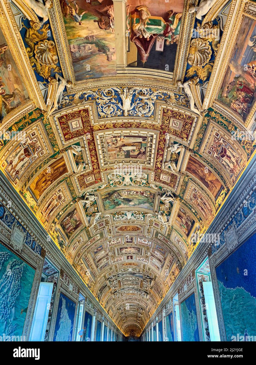A vertical low angle shot of a long hall ceiling in Vatican, Italy ...