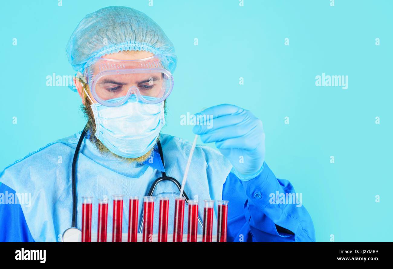 Doctor checking blood samples in lab. Male researcher in personal ...