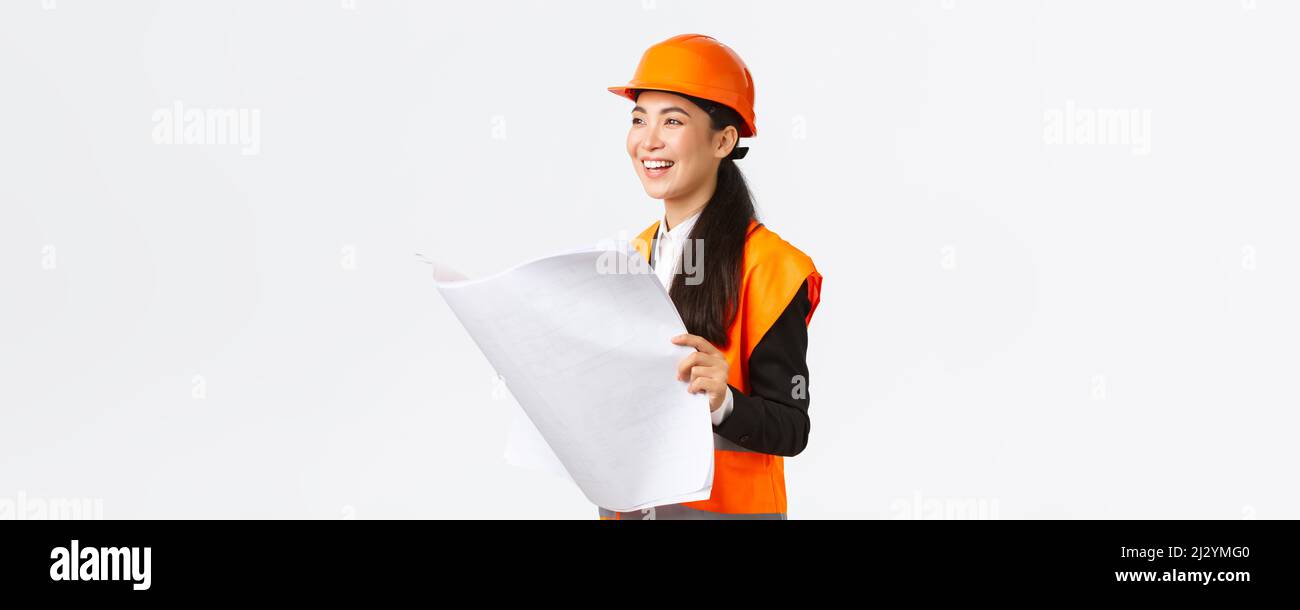 Satisfied happy asian female chief engineer looking at results of ...