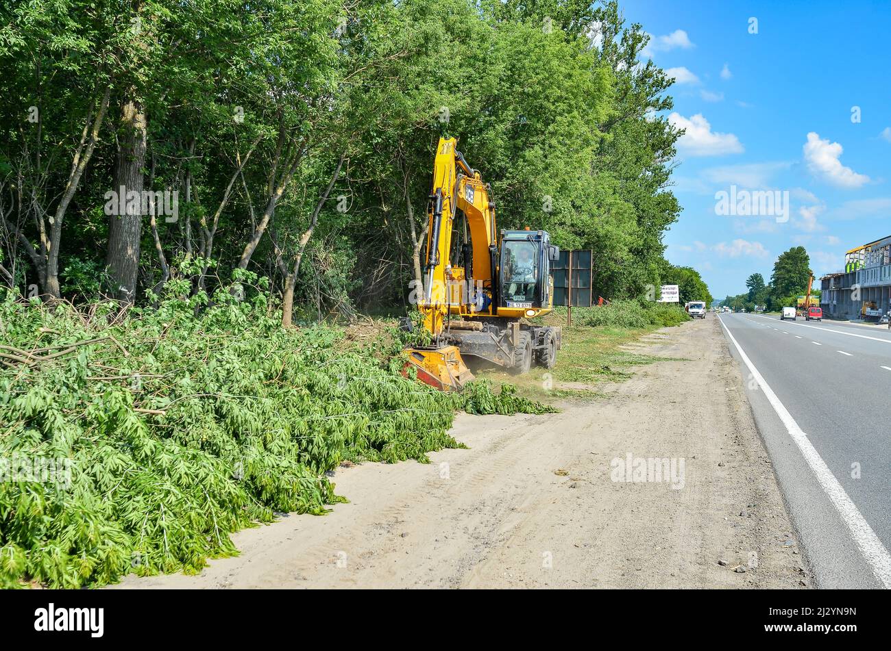 Mulcher clears roadside of vegetation. Road works Stock Photo - Alamy