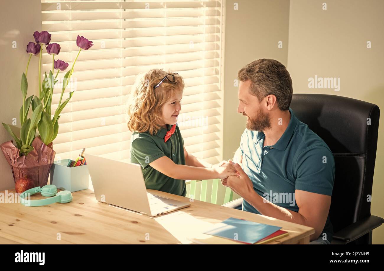 happy dad helping his school son child in glasses study with computer ...