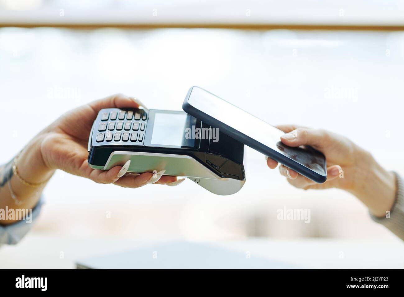 Side view close up of waitress giving bank payment machine to client to ...
