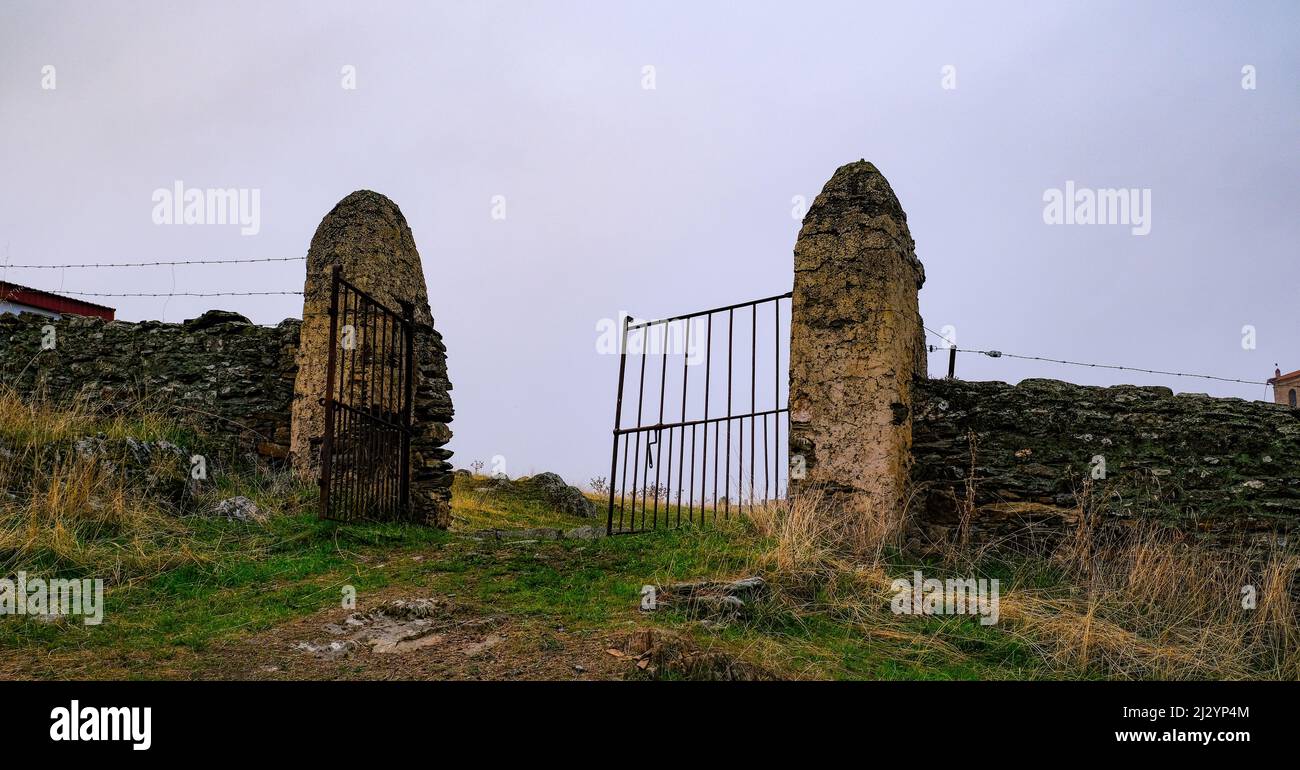 A shot of an ancient fence and old metal gate in green natural area in ...