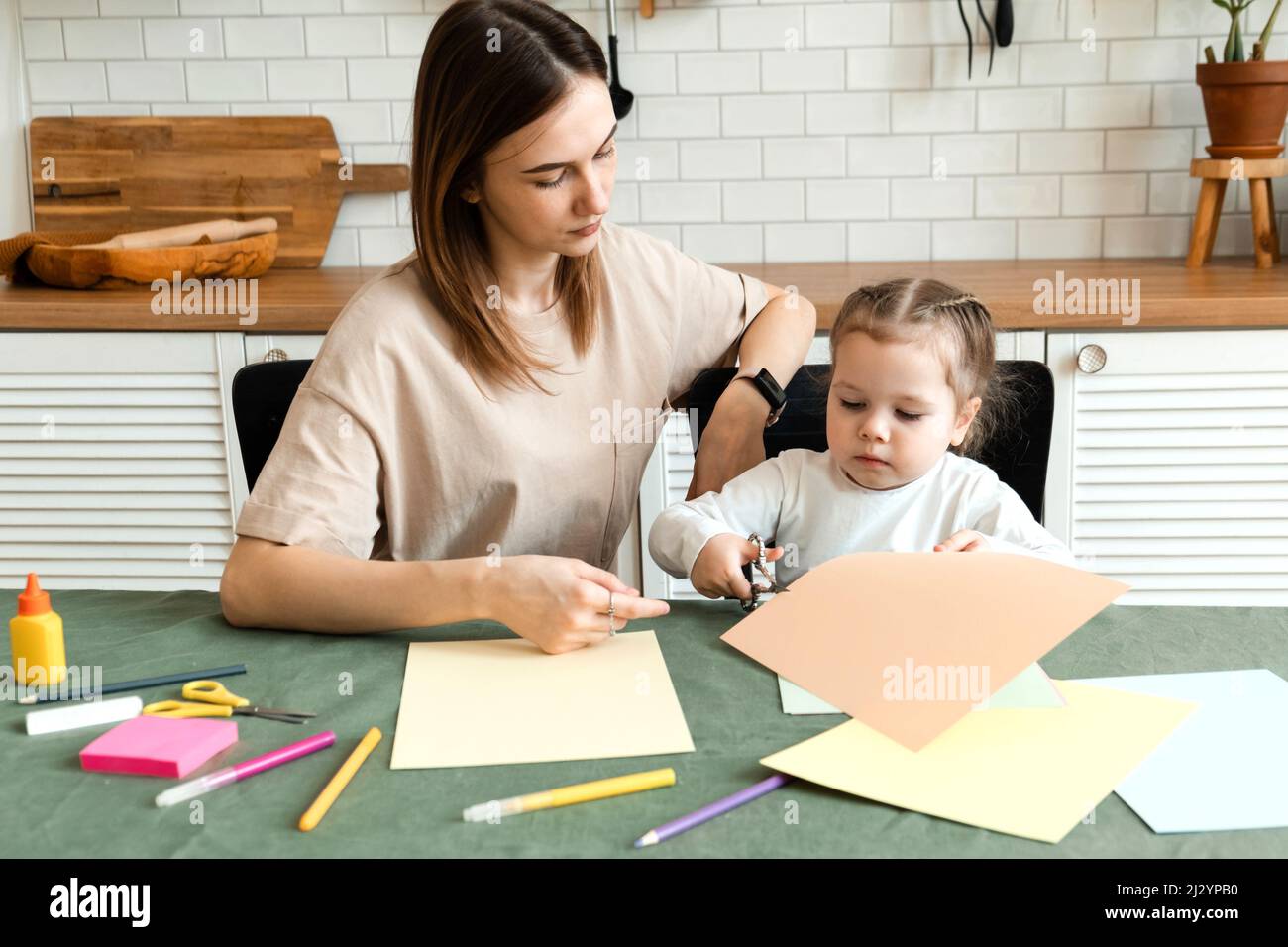 Mother and little daughter enjoy a creative morning by making crafts ...