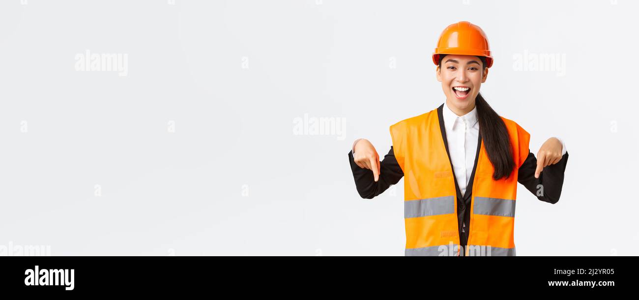 Excited smiling asian female engineer, industrial woman in safety ...